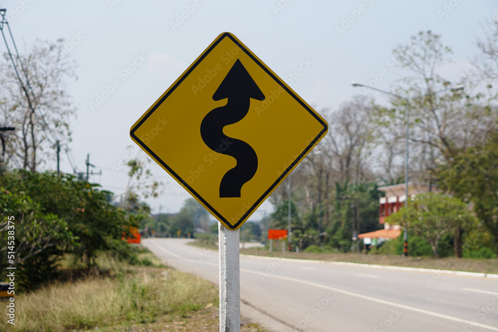Yellow traffic sign with twisty arrow symbol at rural road Thailand to ...