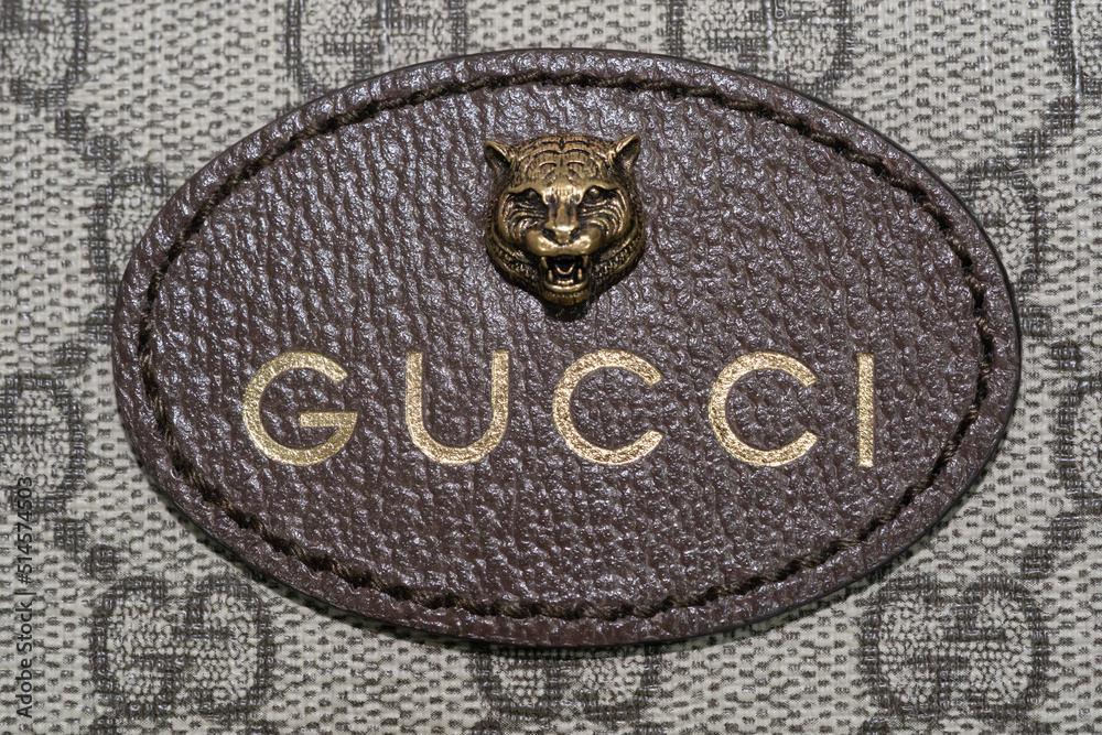 Close up of golden GUCCI logo on leather badge with golden tiger head ...