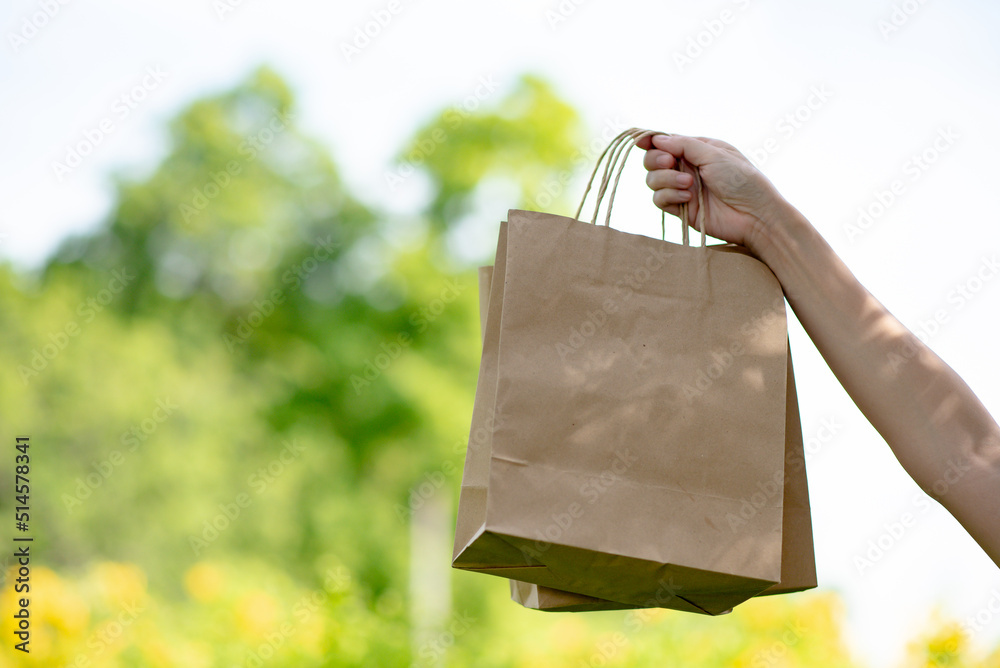 Hand holding paper bags that are environmentally friendly, reduce or ...