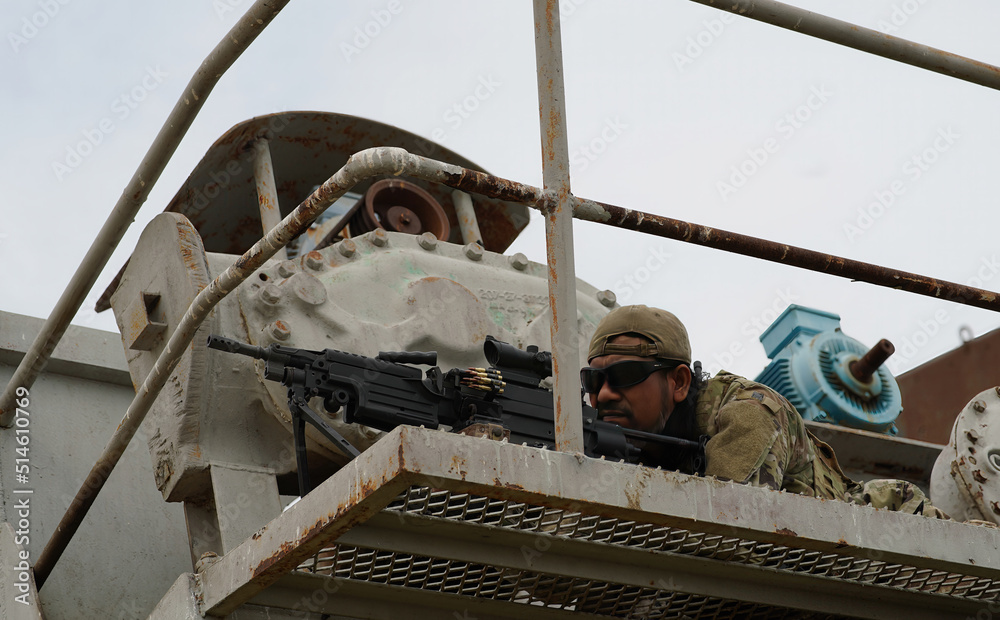 Military sniper lay body hide on the industrial platform aiming sniper ...
