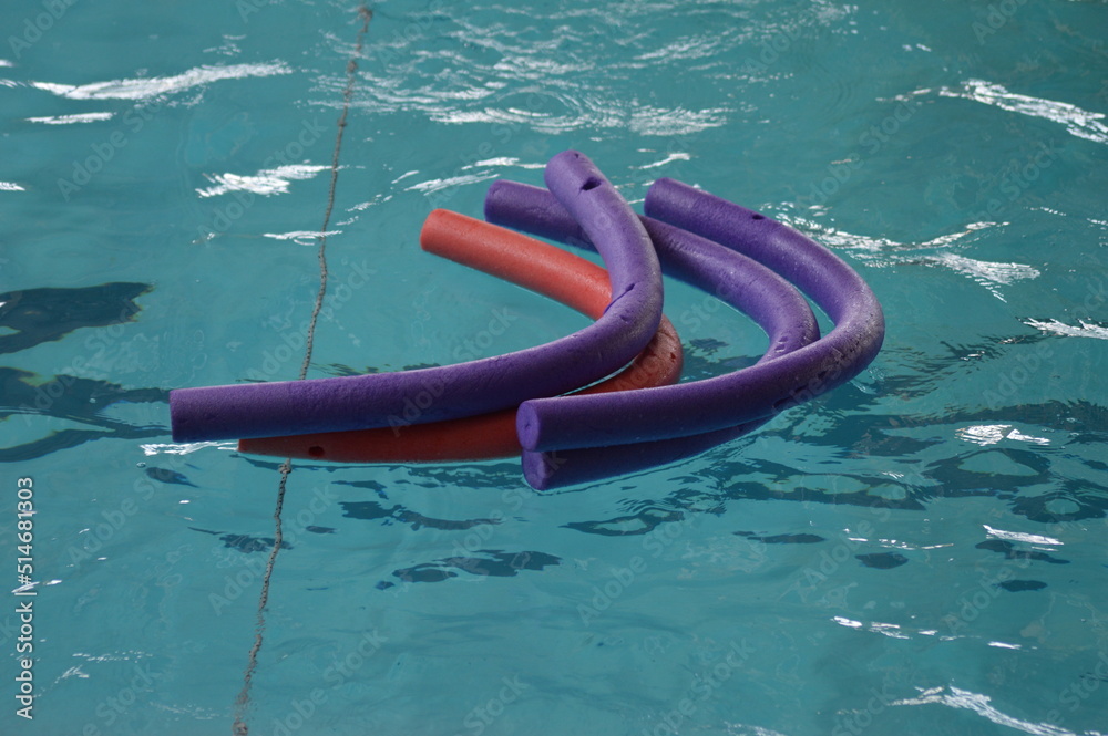 Three purple and one red swimming floating foam in the pool, equipment ...