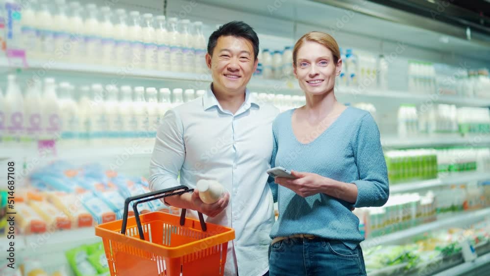 Portrait of a happy asian couple of consumers, supermarket shoppers or ...