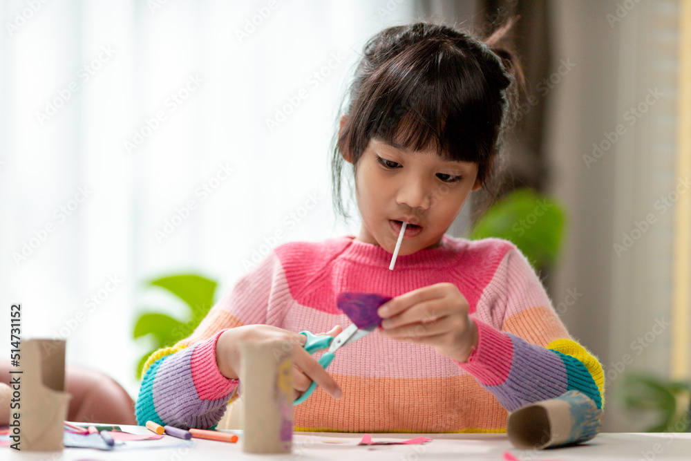 Portrait of a little asian girl cutting a paper in activities on DIY ...