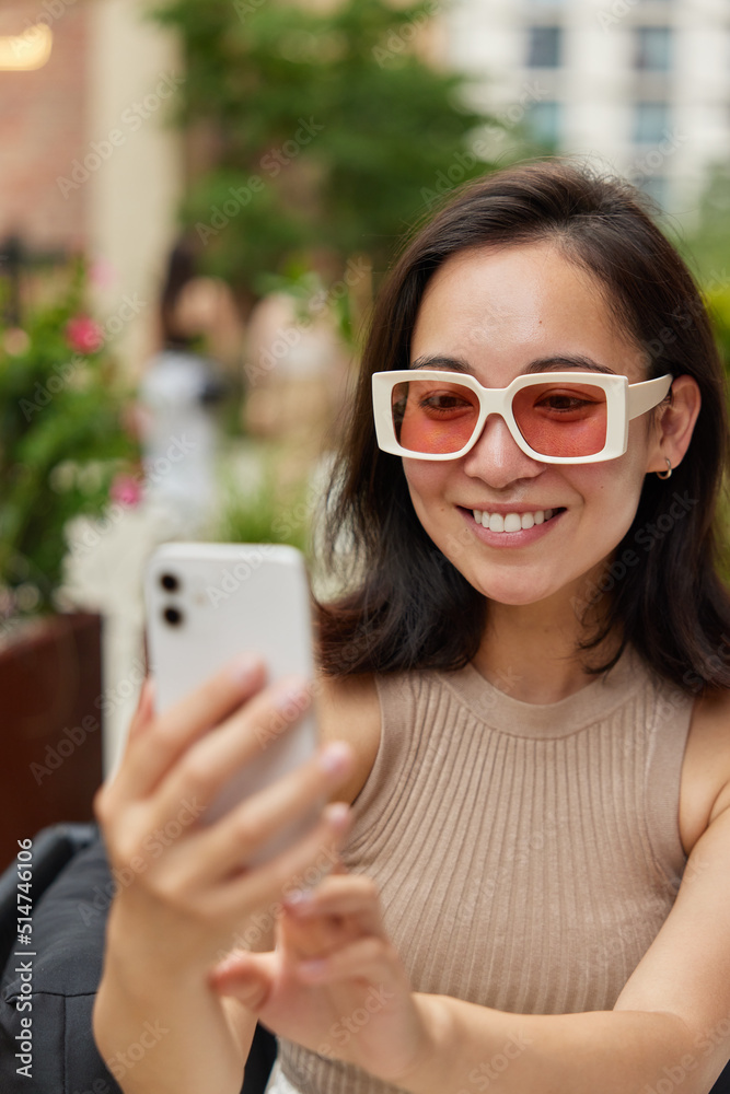 Glad beautiful millennial girl with happy expression clicks selfie via ...