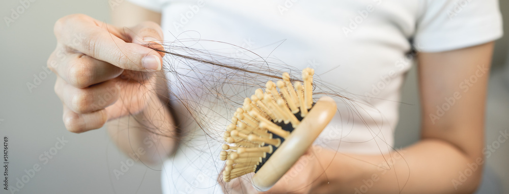 Hair fall problem concept. Shocked Asian woman looking at many hair ...