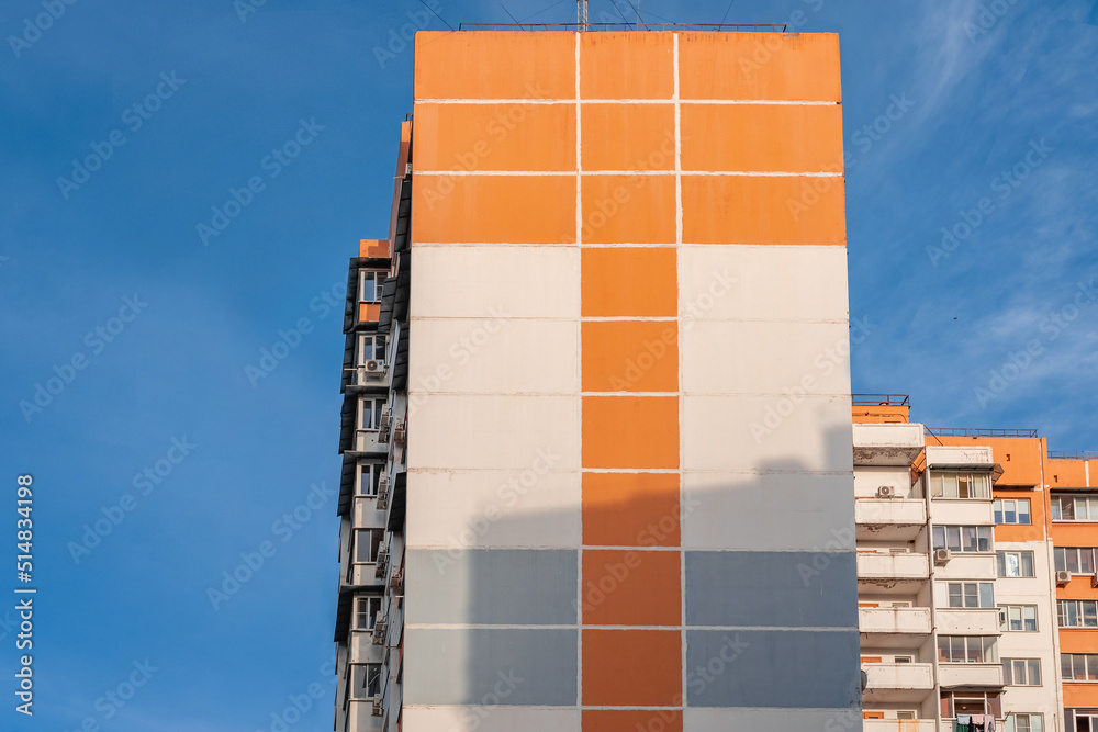 Yellow-white wall of a multi-storey residential building. A tall yellow ...