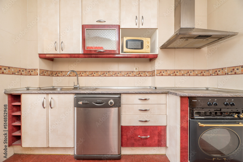 kitchen with cream and bright red furniture with integrated appliances ...