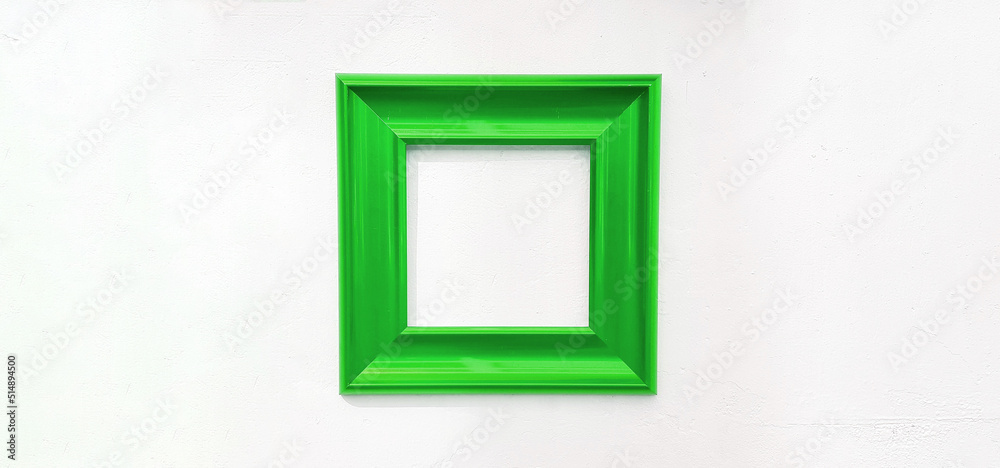 Green empty picture frame isolated on white wall with copy space ...