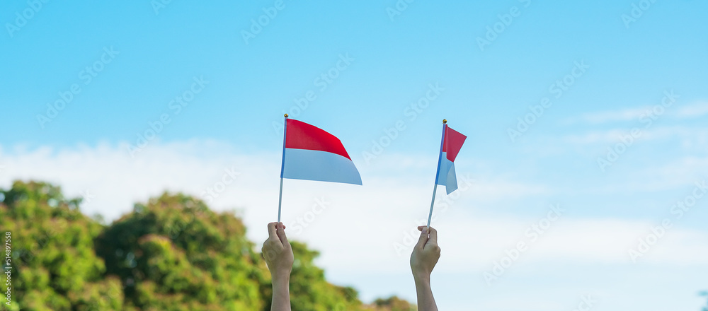 Hand Holding Indonesia Flag On Blue Sky Background Indonesia