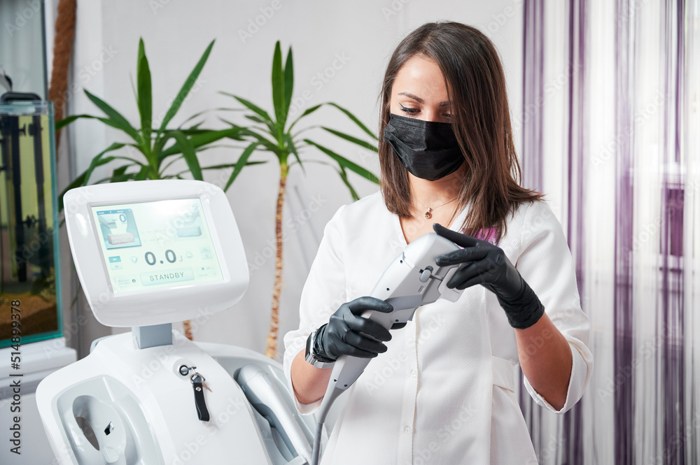 Clinic of aesthetic medicine. Cosmetologist in protective mask and ...