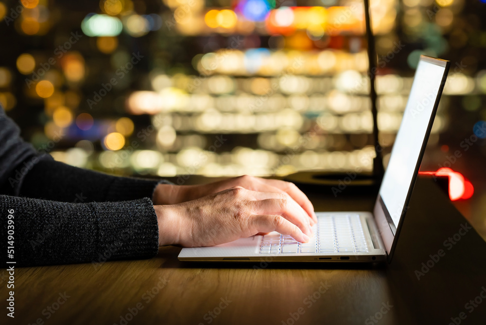 Working with computer at night, out focus city skyline background Stock ...