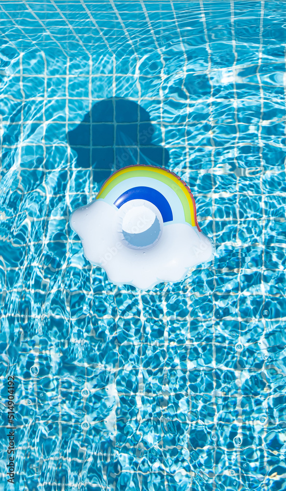 Colorful inflatable ring float in swimming pool background with bright ...