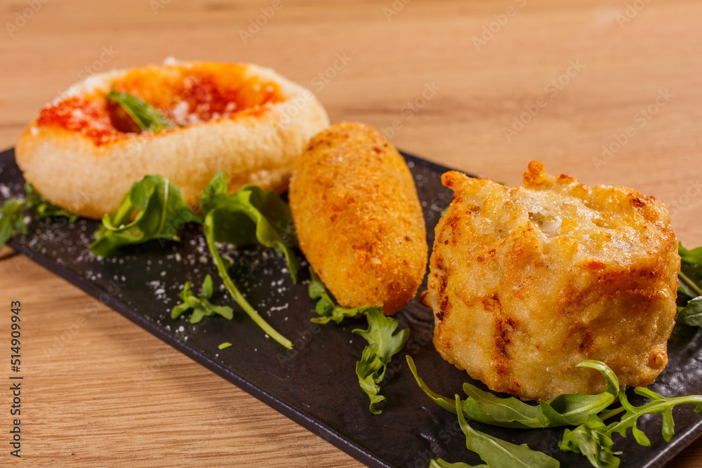Tris di antipasti fritti di una pizzeria napoletana. Una montanara con ...