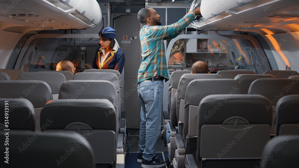 Diverse group of tourists flying in economy class by airplane, chatting ...