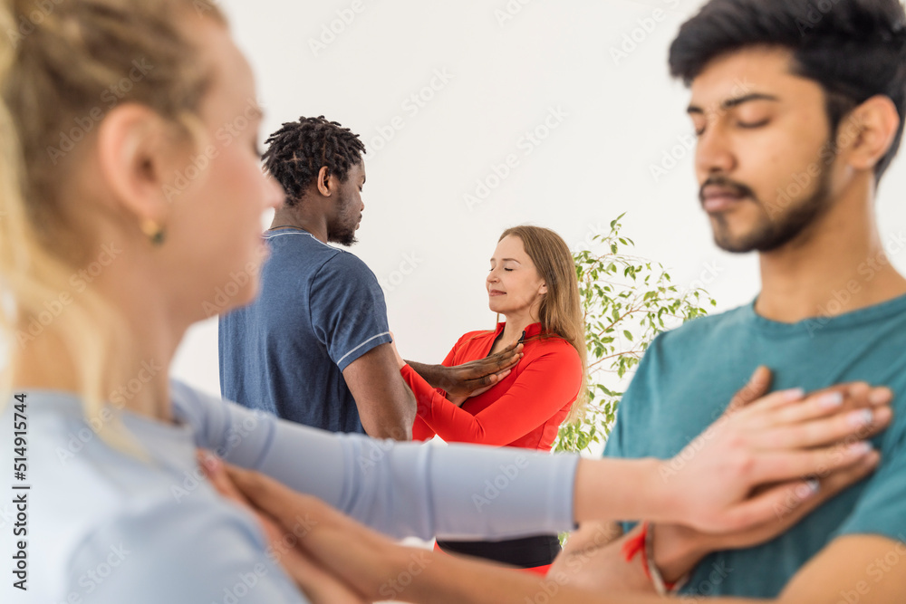 Couples with eyes closed touching chest of each other practicing yoga ...