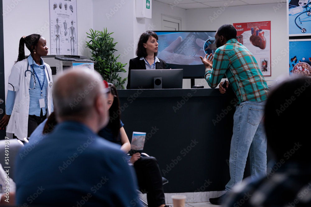 African american patient talking with private clinic receptionist ...