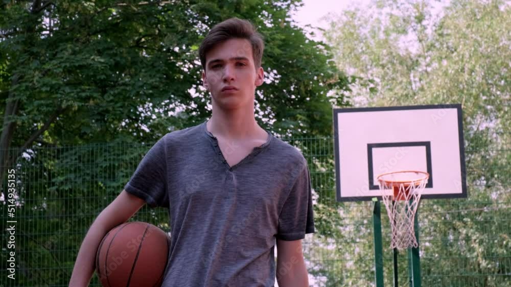 Vidéo Stock Teenager is going with a basketball in his hand is on the ...
