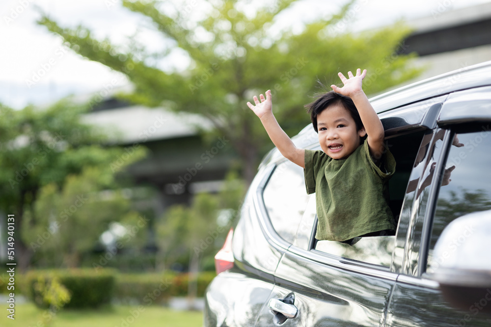 Happy asian boy waving hands gesturing hello out of the car window ...