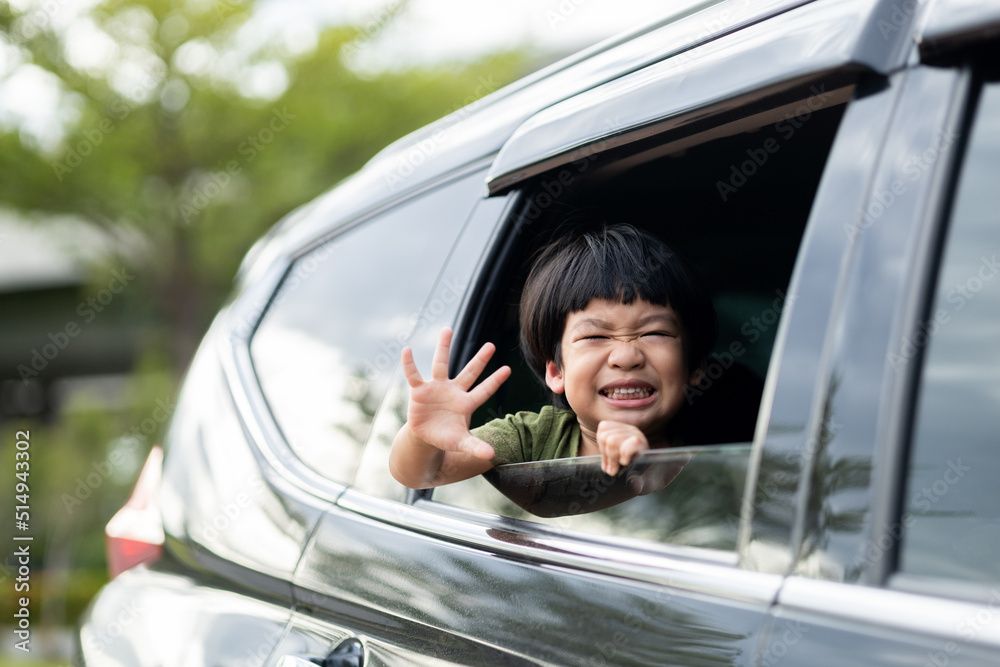 Happy asian boy waving hands gesturing hello out of the car window ...