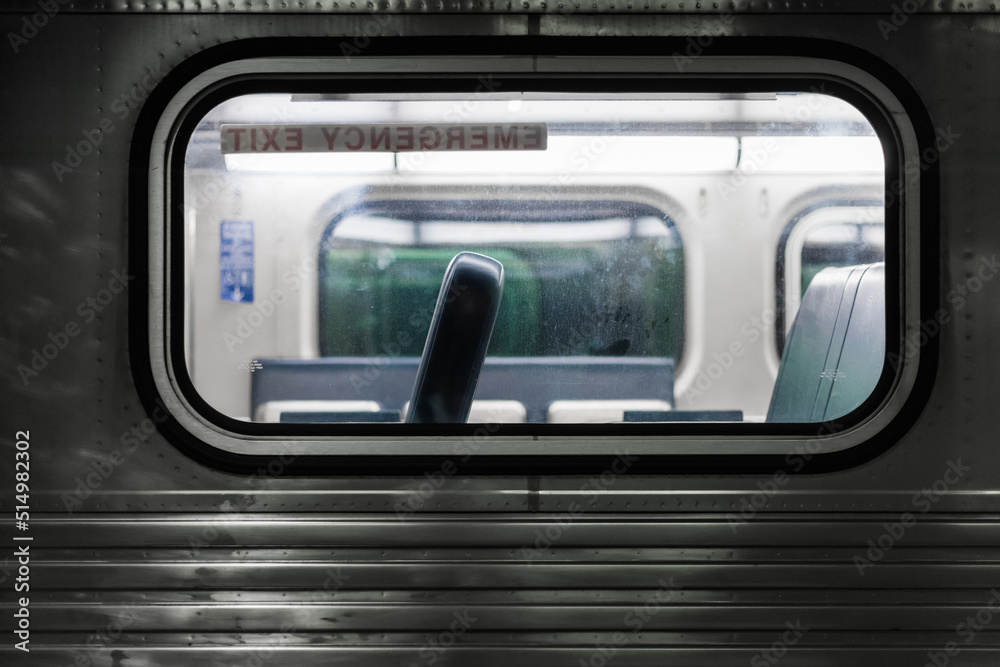 Looking through the window of an empty commuter train car in a dark ...