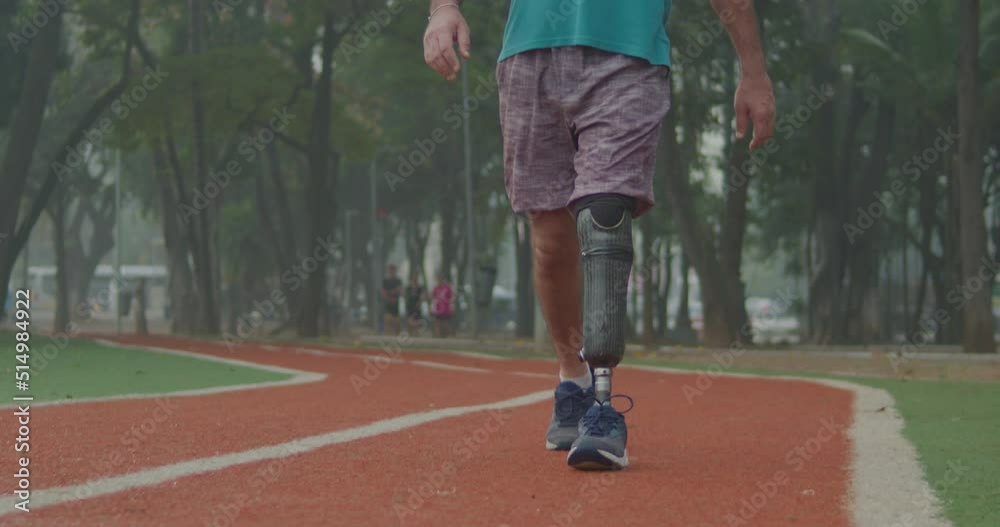 Athletic amputee with prosthetic leg walking forward at parkAthletic ...