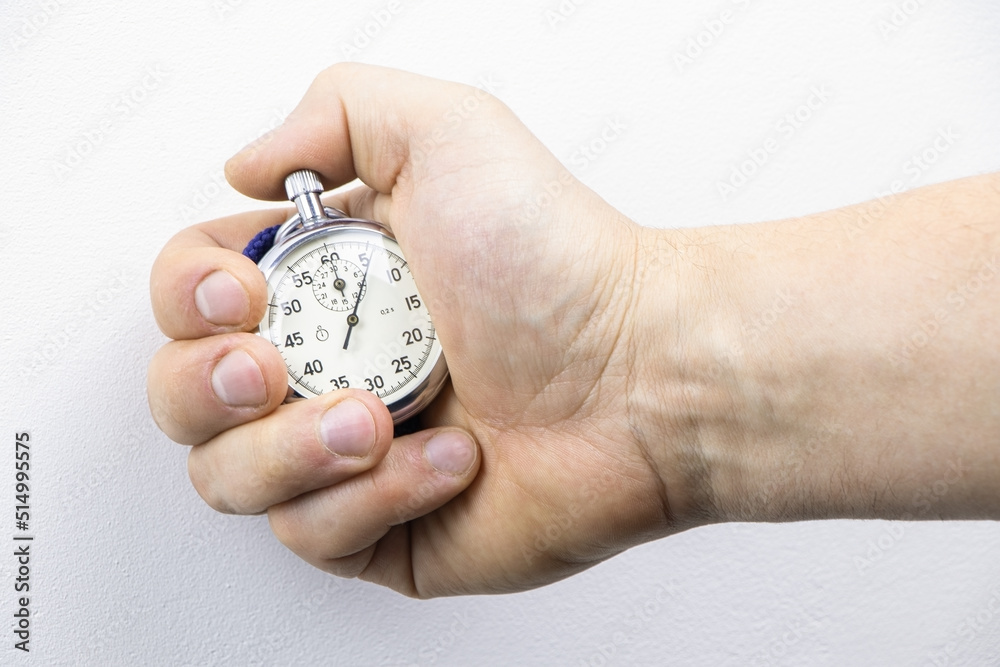 Analog stopwatch close-up. Man's hand holding a stopwatch.Counting time ...
