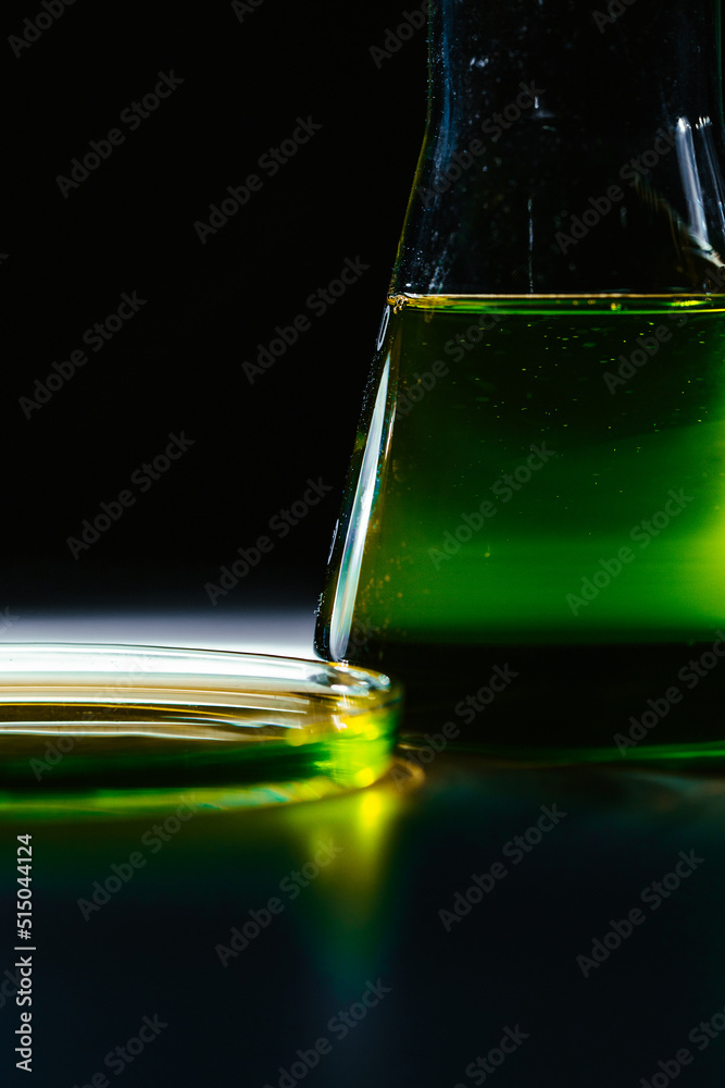 Petri dishand retort with green and blue with a chemical reagent ...