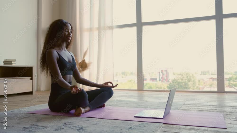 Young calm fit healthy African black woman sitting on floor at home ... Young calm fit healthy African black woman sitting on floor at home ...