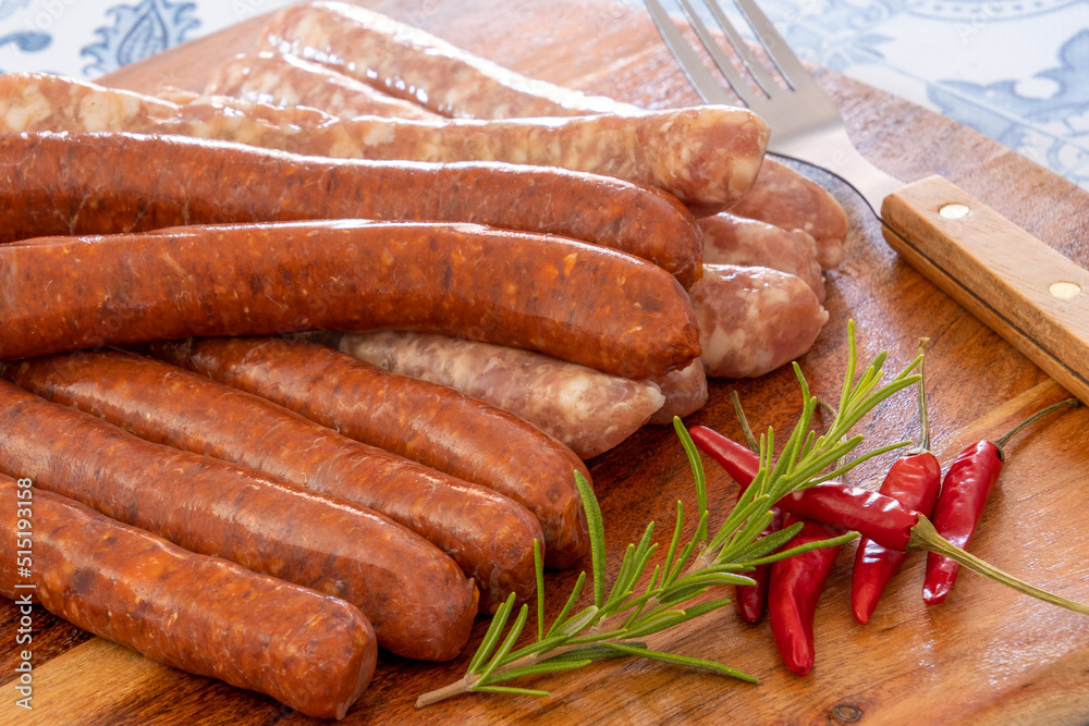 Foto de gros plan de saucisses et merguez crues sur la grille de barbecue do Stock | Adobe Stock