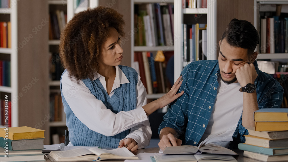 Two students guy and girl sitting at desk classroom writes notes in ...