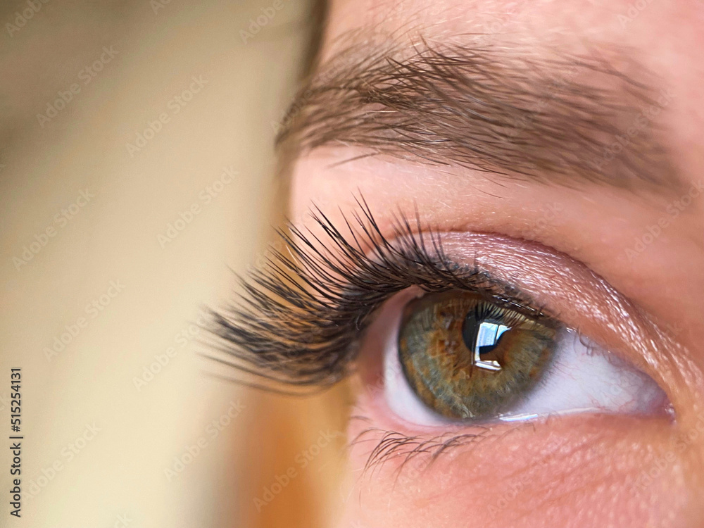 The procedure of classical eyelash extension. Beautiful female eyes ...