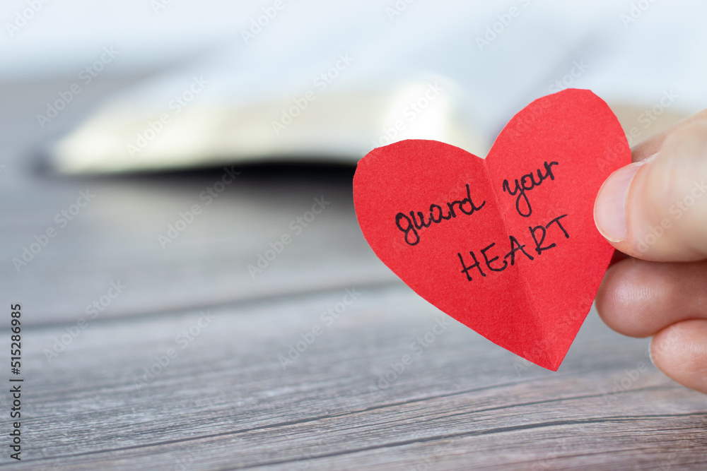 Guard your heart, a handwritten text verse on red paper with an open ...