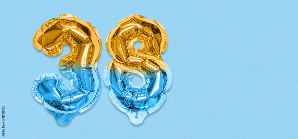Rainbow foil balloon number, digit thirty eight on a blue background ...