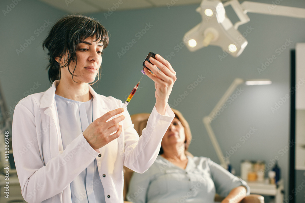 Female doctor preparing botox injection, patient in background Stock ...