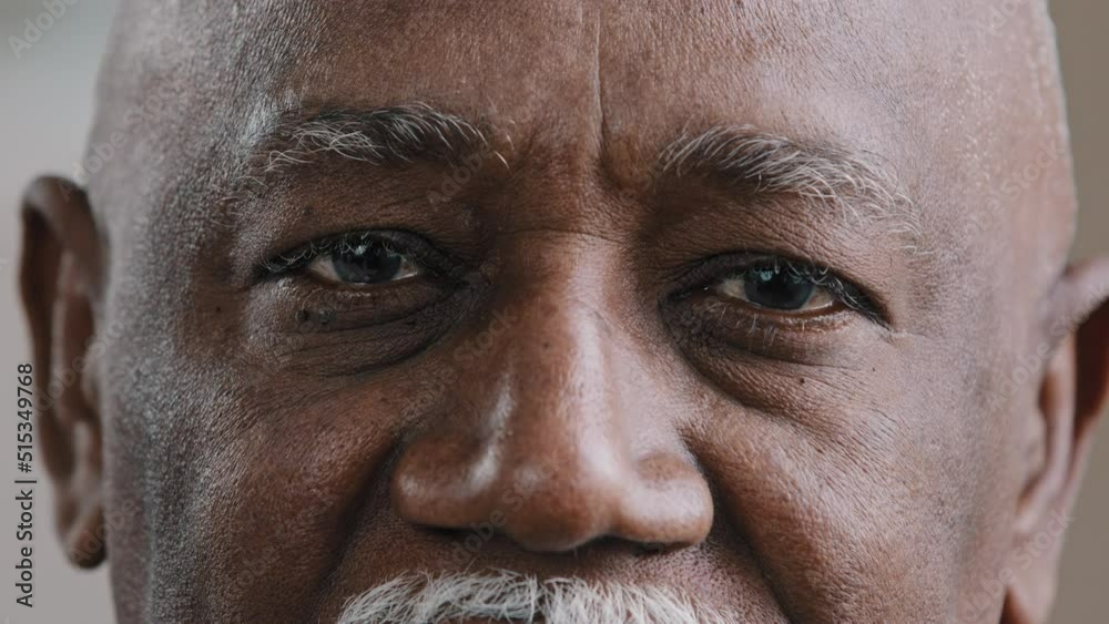 Close-up male dark eyes wrinkled face African American old man looking ...