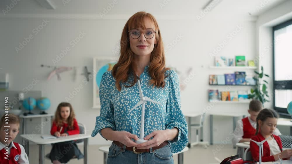 Elementary school teacher holding wind turbine and learning kids about ...