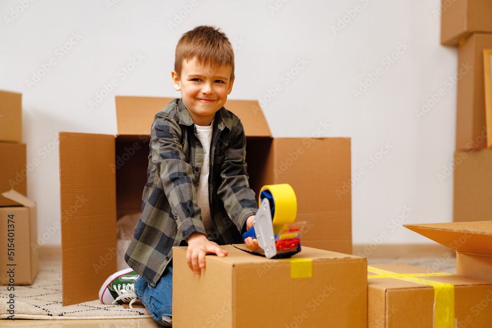 Little boy packing a moving box for a new home Stock Photo | Adobe Stock