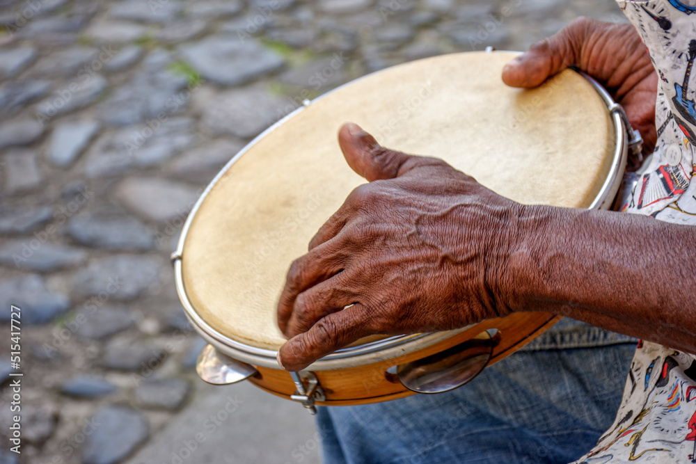 Hands and instrument of percussionist playing tambourine in the streets ...