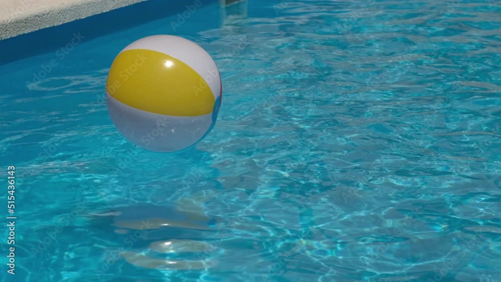 Vidéo Stock Colourful inflatable beach ball floating in shiny blue ...