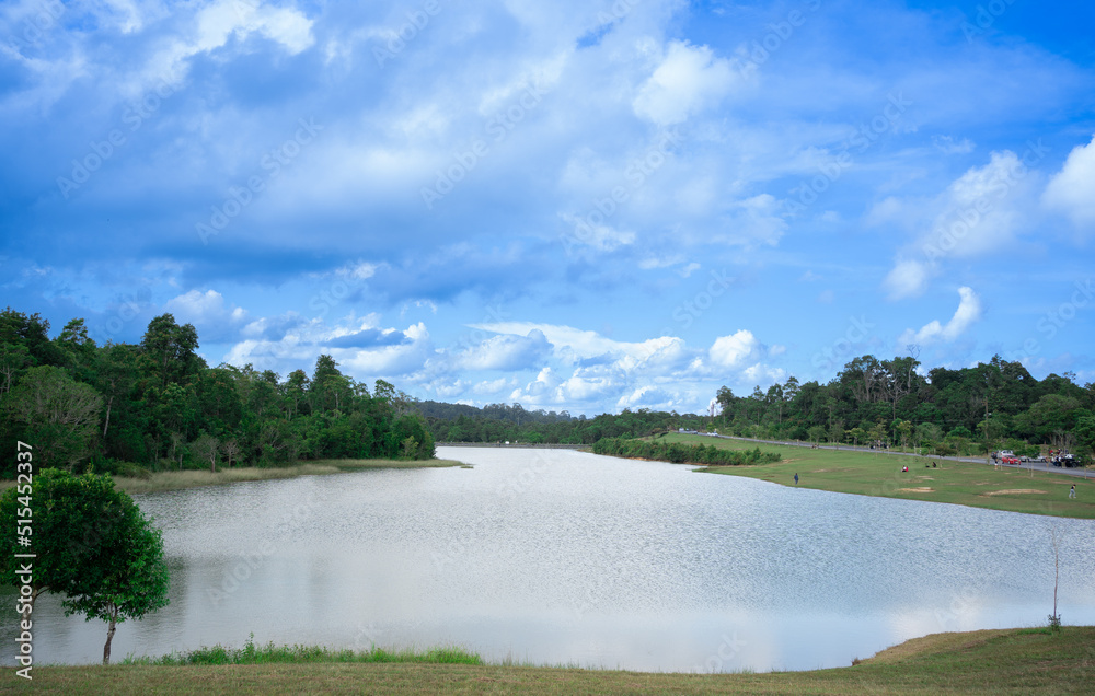 Bright sky over a green field and forest and river after the rain ...