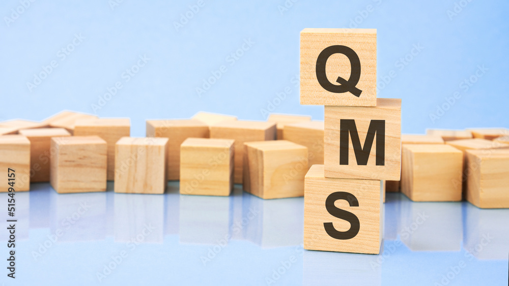 QMS. wooden cubes. blocks lie on a black background. stacks with coins ...