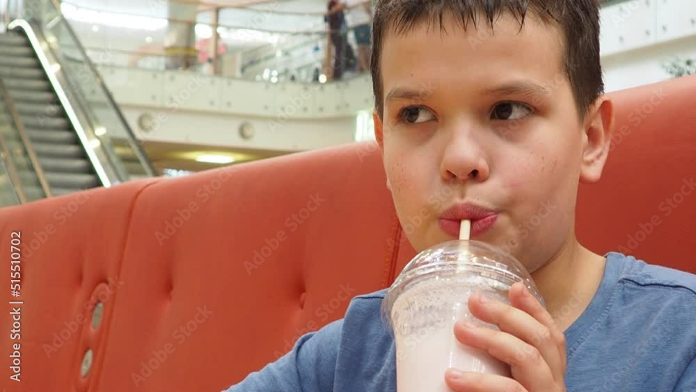 Adorable kid teenage boy drinking milkshake or healthy fruits and ...
