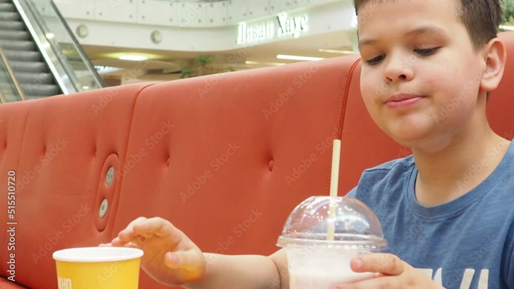 Adorable kid teenage boy drinking milkshake or healthy fruits and ...