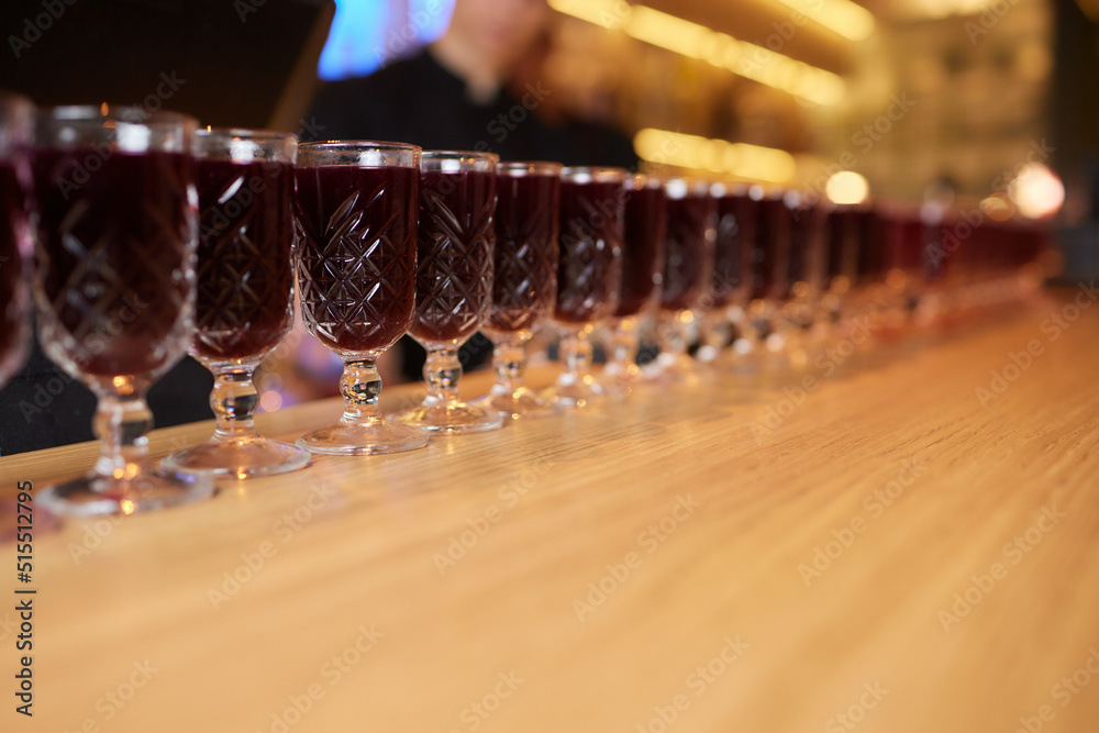 cocktails shots are on a tray on the bar counter. red cocktail shots on ...