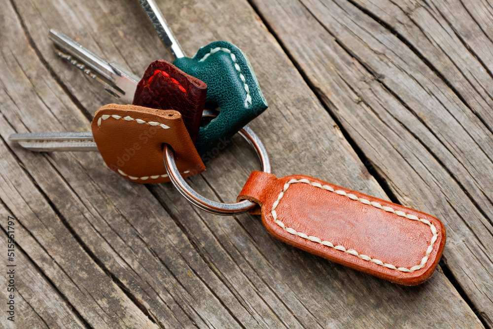 Blank leather keychain for logo. A bunch of keys on an old wooden ...
