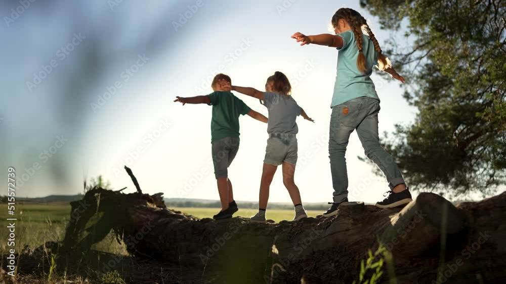 Group of children walks on a log in the park. People on the log ...