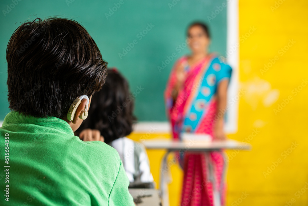 kid with hearing aid machine listening lesson at classroom showing with ...