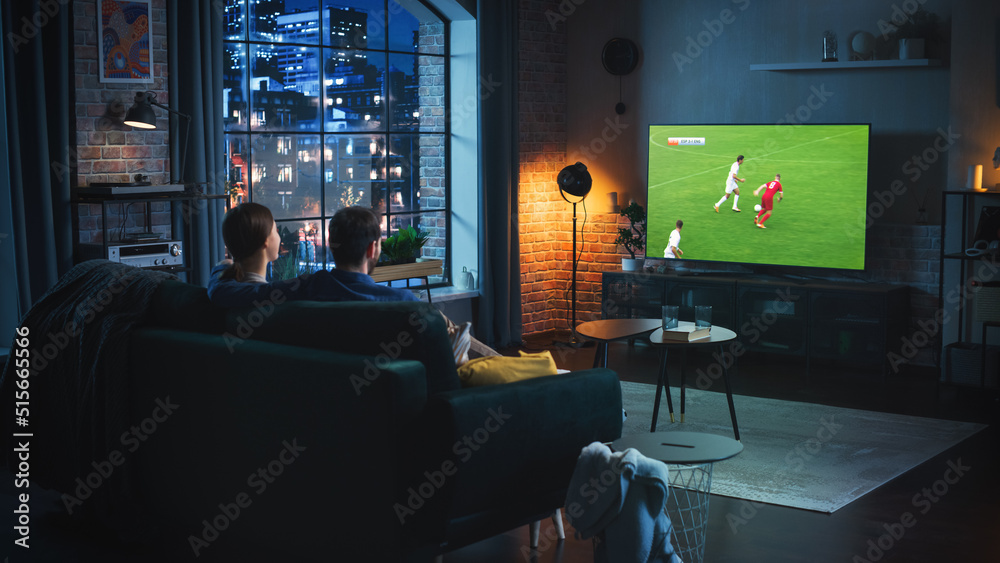 Couple of Soccer Fans Relax on a Couch, Watch a Sports Match at Home in ...