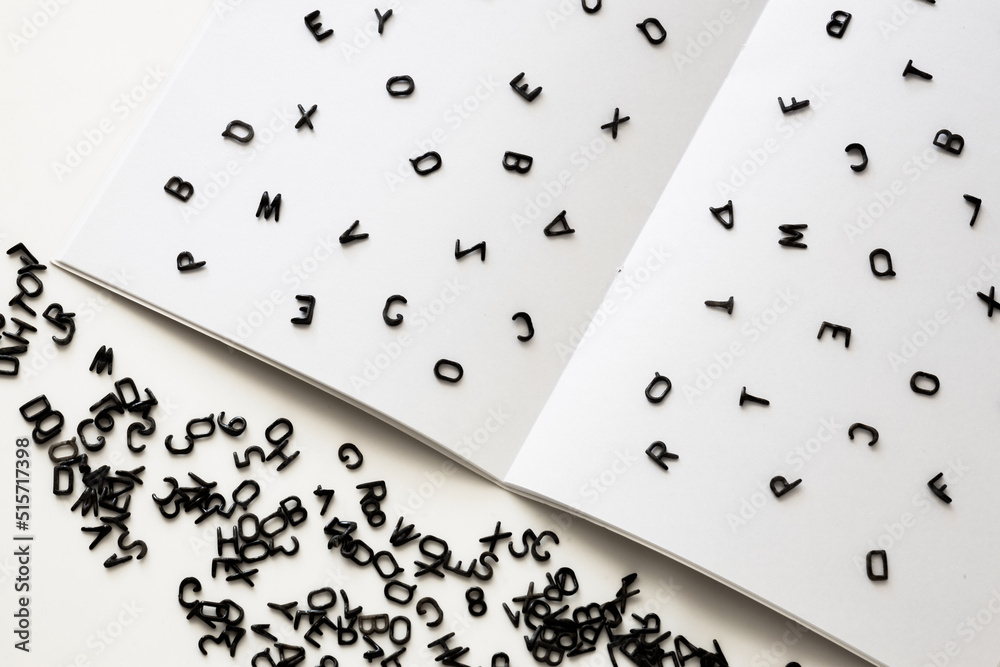 letters of the English alphabet are scattered on a blank white sheet ...