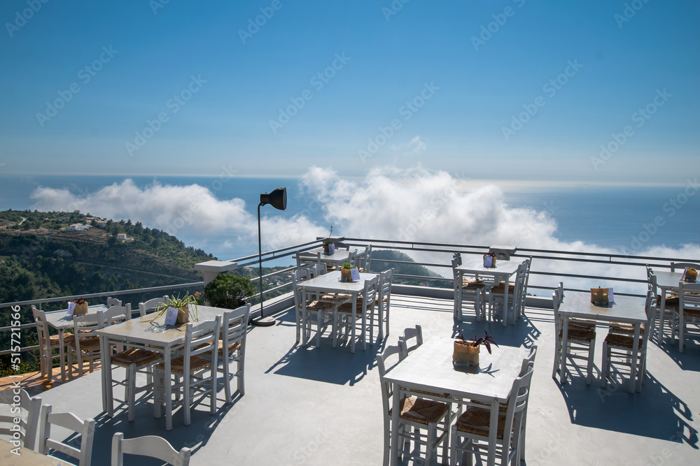 Restaurant white tables on a balcony next to the clouds at Lefkada ...